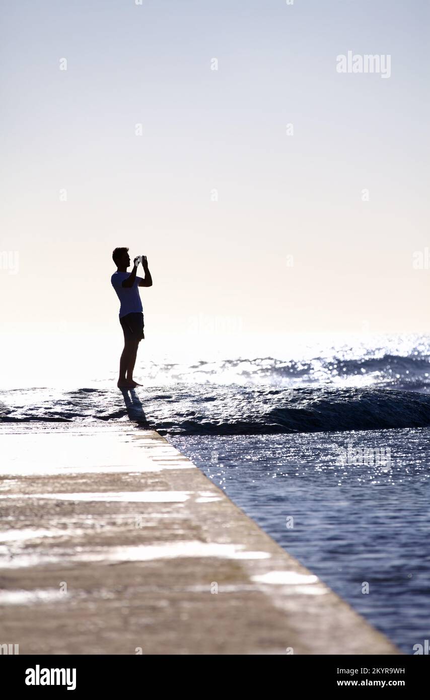 Hes one with the ocean. Full-length concept shot of a young man ...
