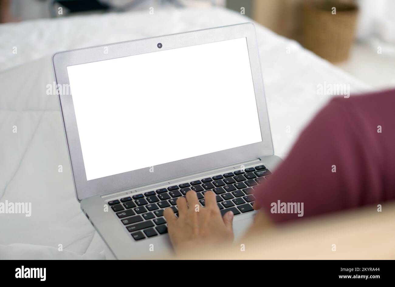 Back view of woman typing on laptop computer keyboard with white screen ...