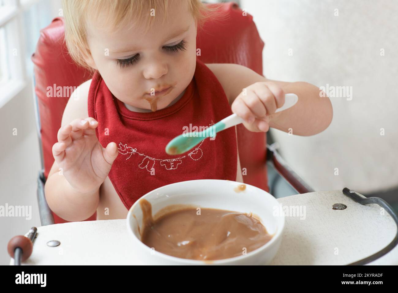 Growing boy needs his food. A young baby boy eating to his hearts ...