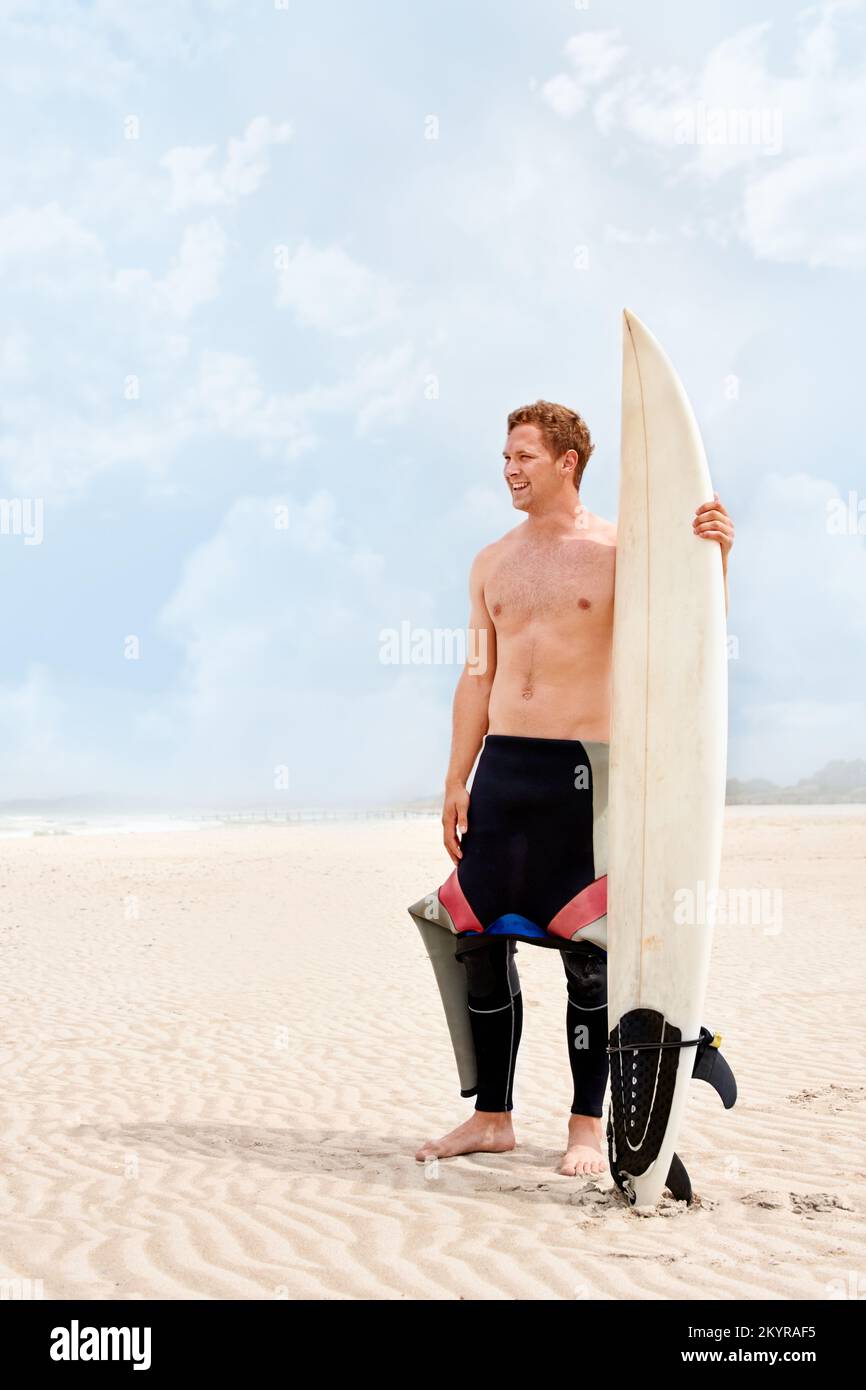 Surfing is a way of life. A young male surfer getting ready to go for a ...