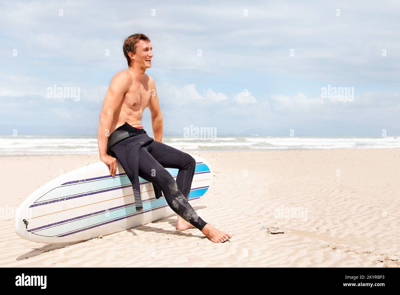 Surfing is a way of life. A young male surfer getting ready to go for a ...