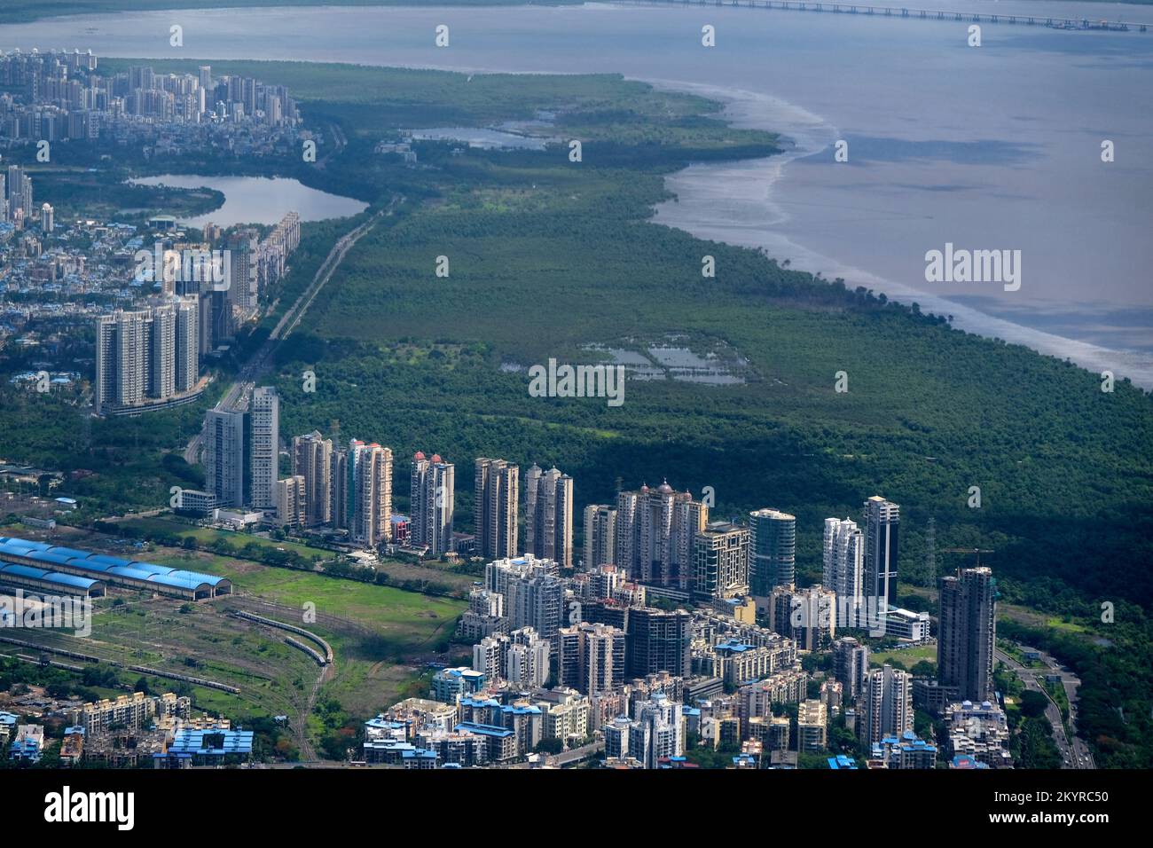 An aerial view of Mumbai's skyline passing over a building with roads ...