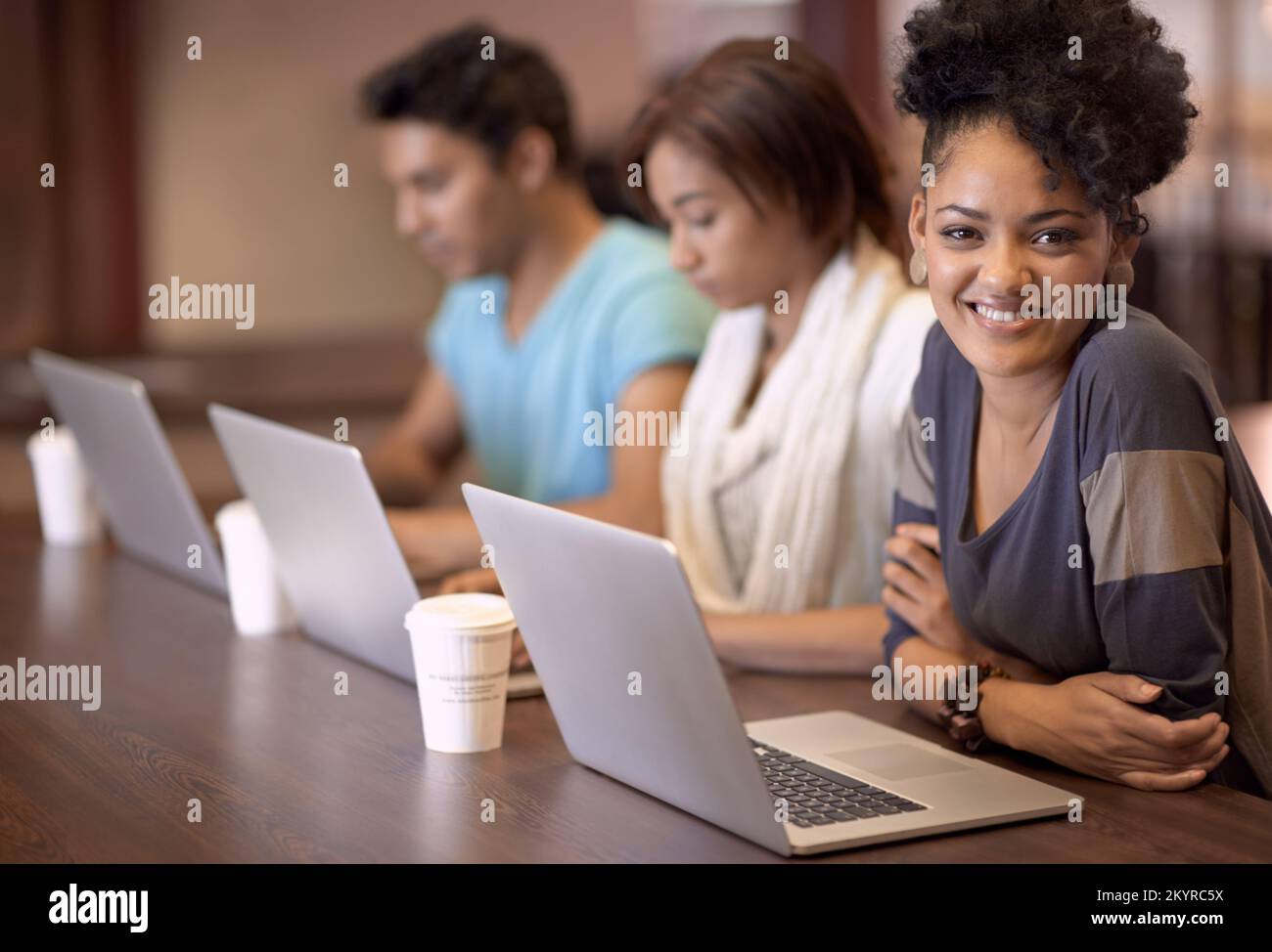 Working towards a bright future. A group of students using a laptop to ...