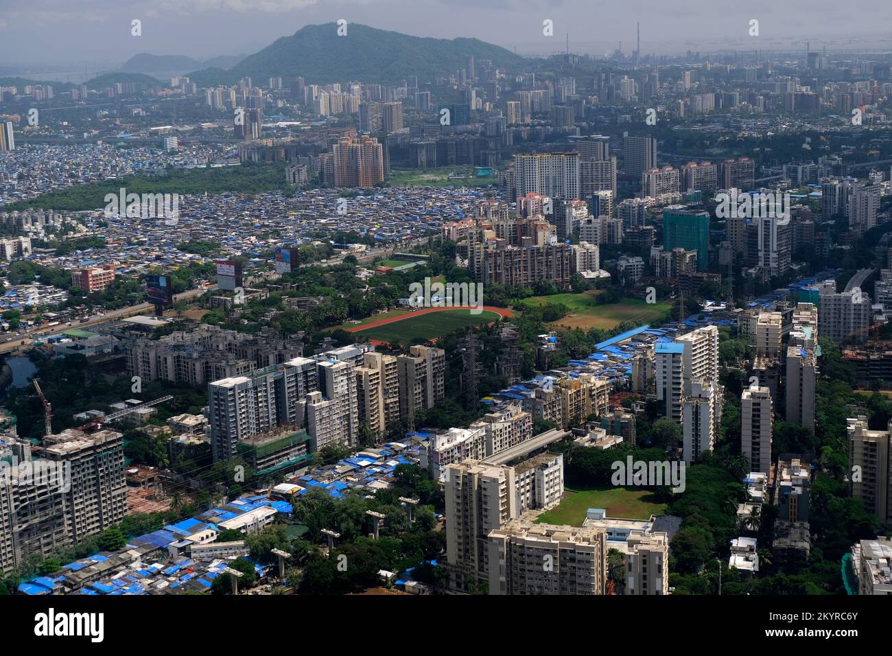 An aerial view of Mumbai's skyline passing over a building with roads ...