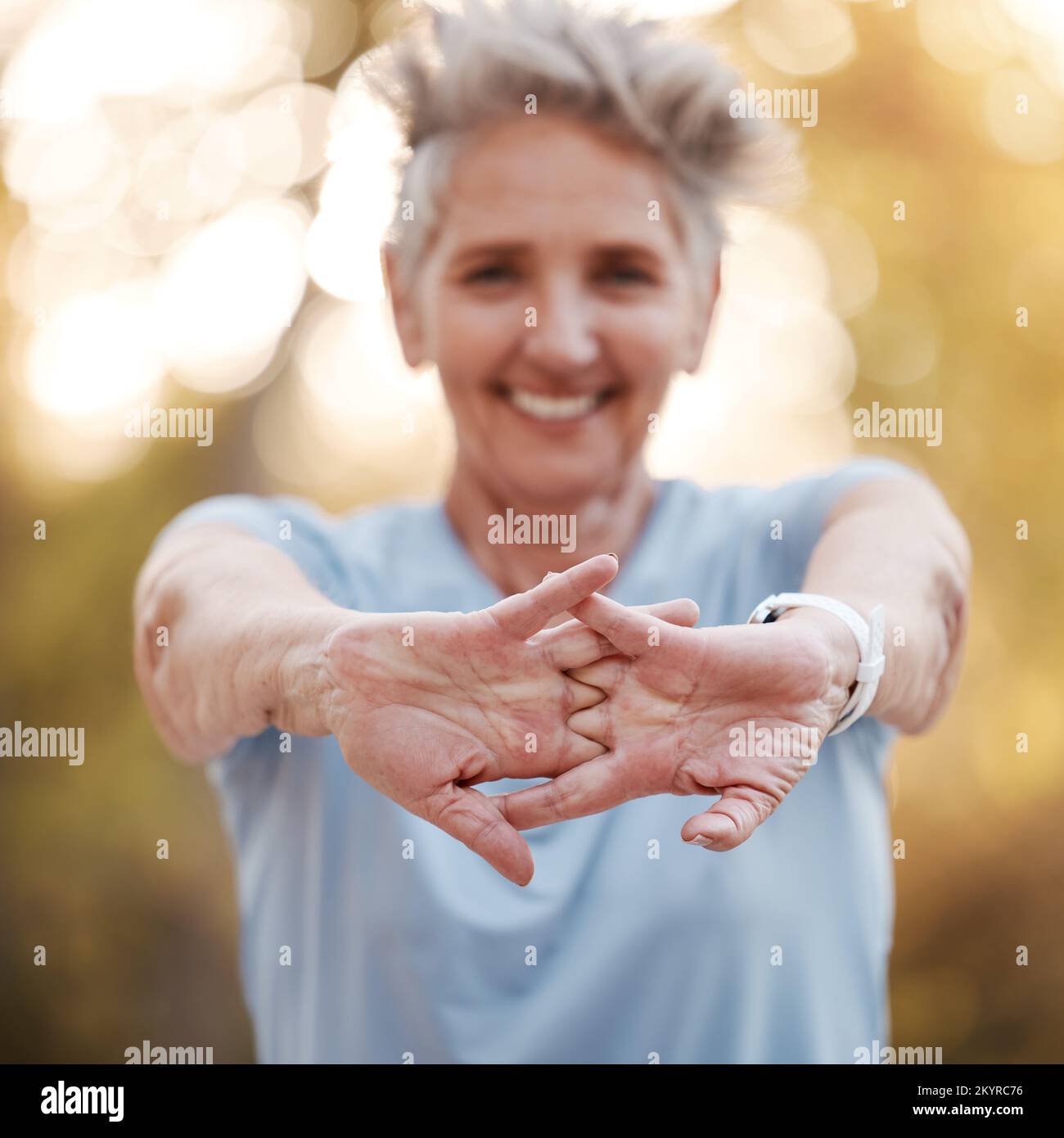 Senior woman, runner stretching hands in park for running, exercise or ...