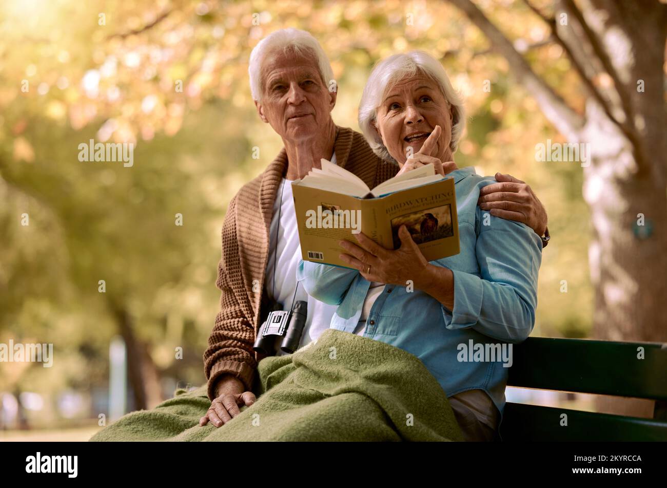 Couple, elderly and reading a book in park, travel and outdoor during ...