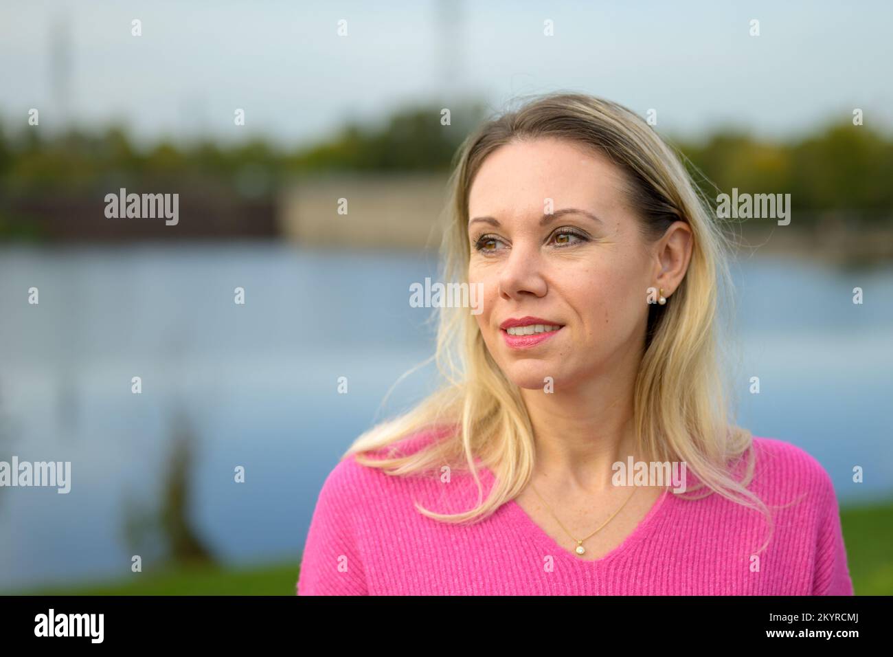 Beautiful woman with pink lipstick and pink sweater looking sideways in ...