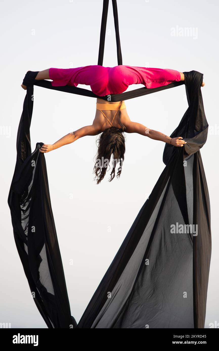Young female aerialist performing on silk outdoors Stock Photo - Alamy