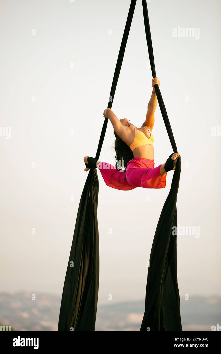 Young female aerialist performing on silk outdoors Stock Photo - Alamy