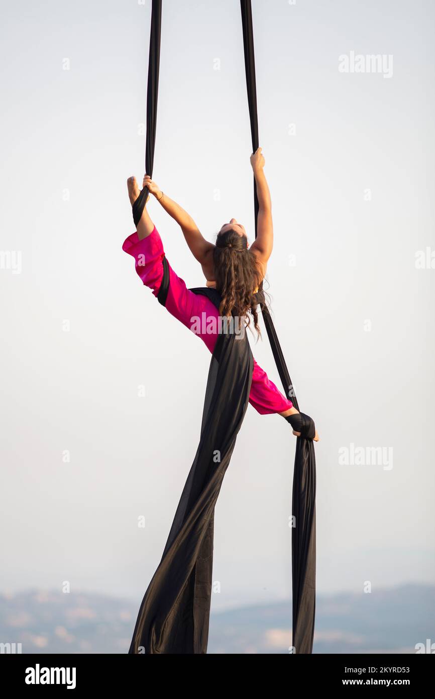 Young female aerialist performing on silk outdoors Stock Photo - Alamy