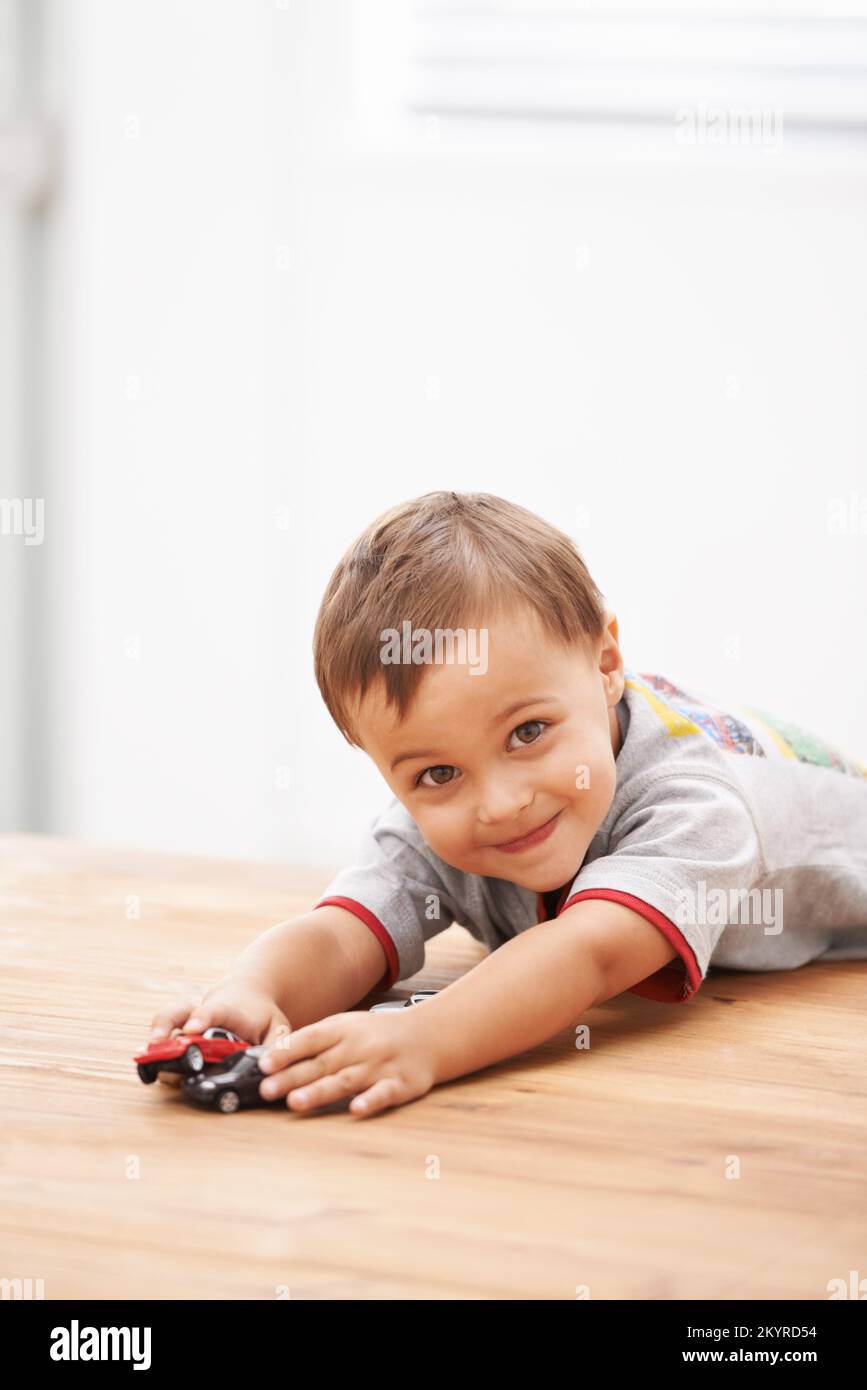 Boys and their toys. Portrait of an adorable young boy playing with toy cars Stock Photo - Alamy