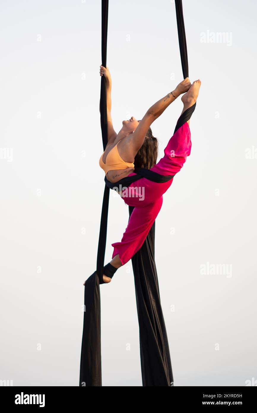 Young female aerialist performing on silk outdoors Stock Photo - Alamy