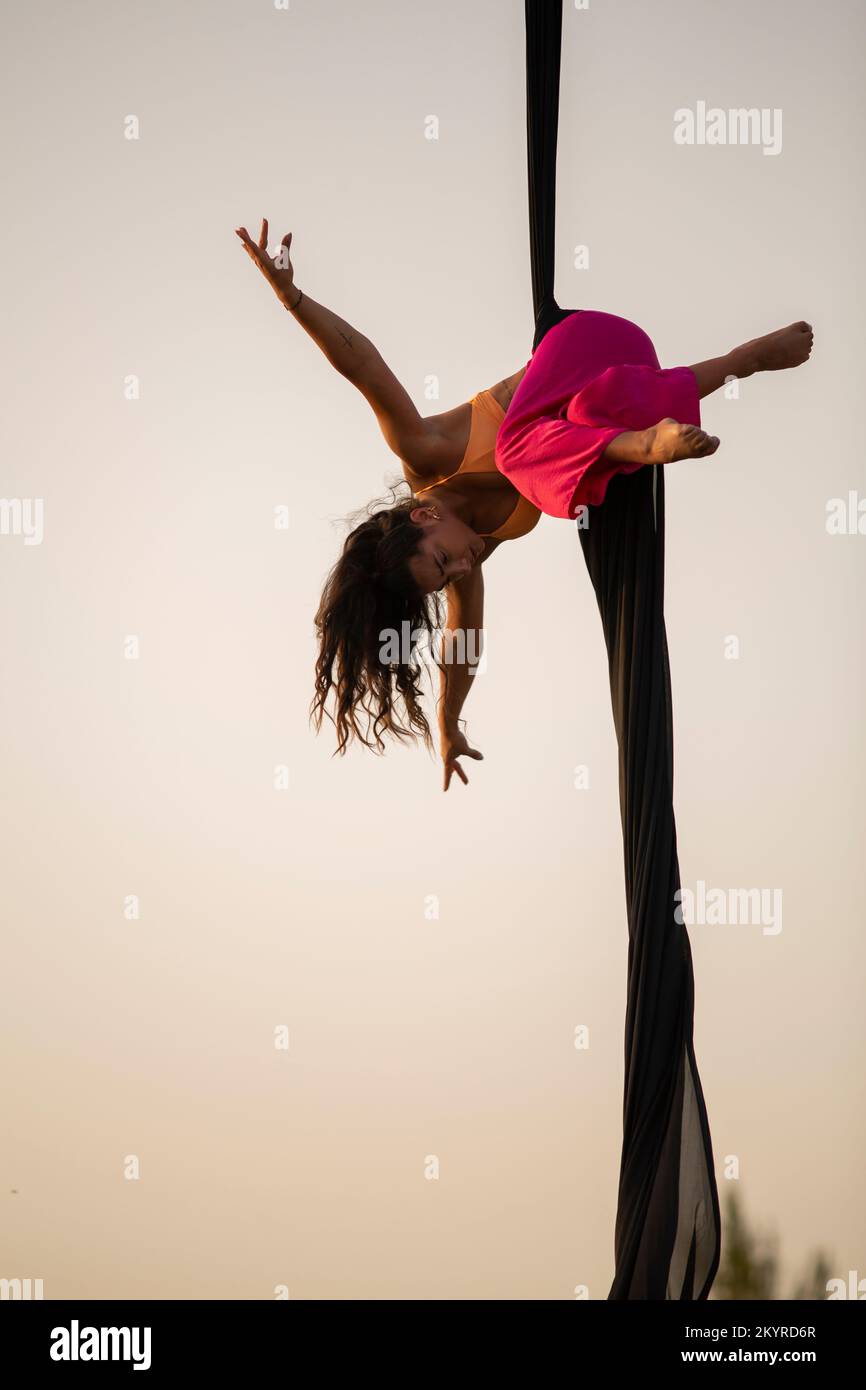 Young female aerialist performing on silk outdoors Stock Photo - Alamy
