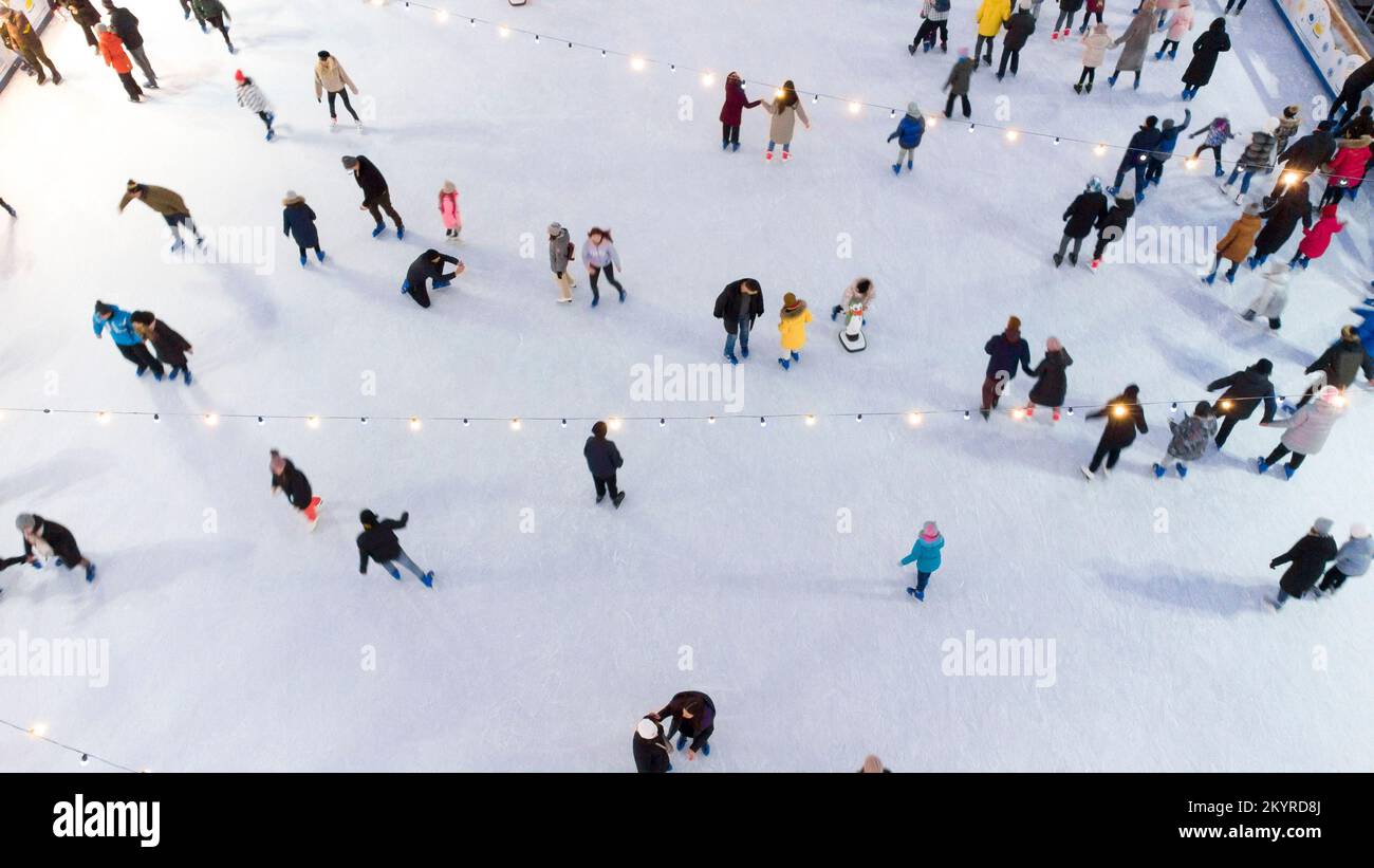 Aerial View many people skating on an open-air ice rink in winter. Ice ...