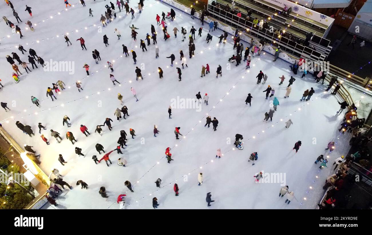 Aerial View many people skating on an open-air ice rink in winter. Ice ...