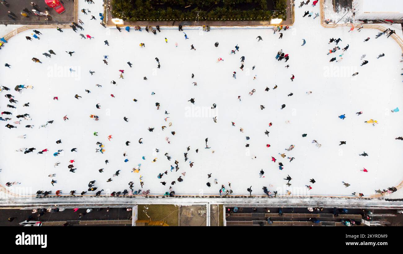 Top view of people skating on large open air ice rink on winter day ...