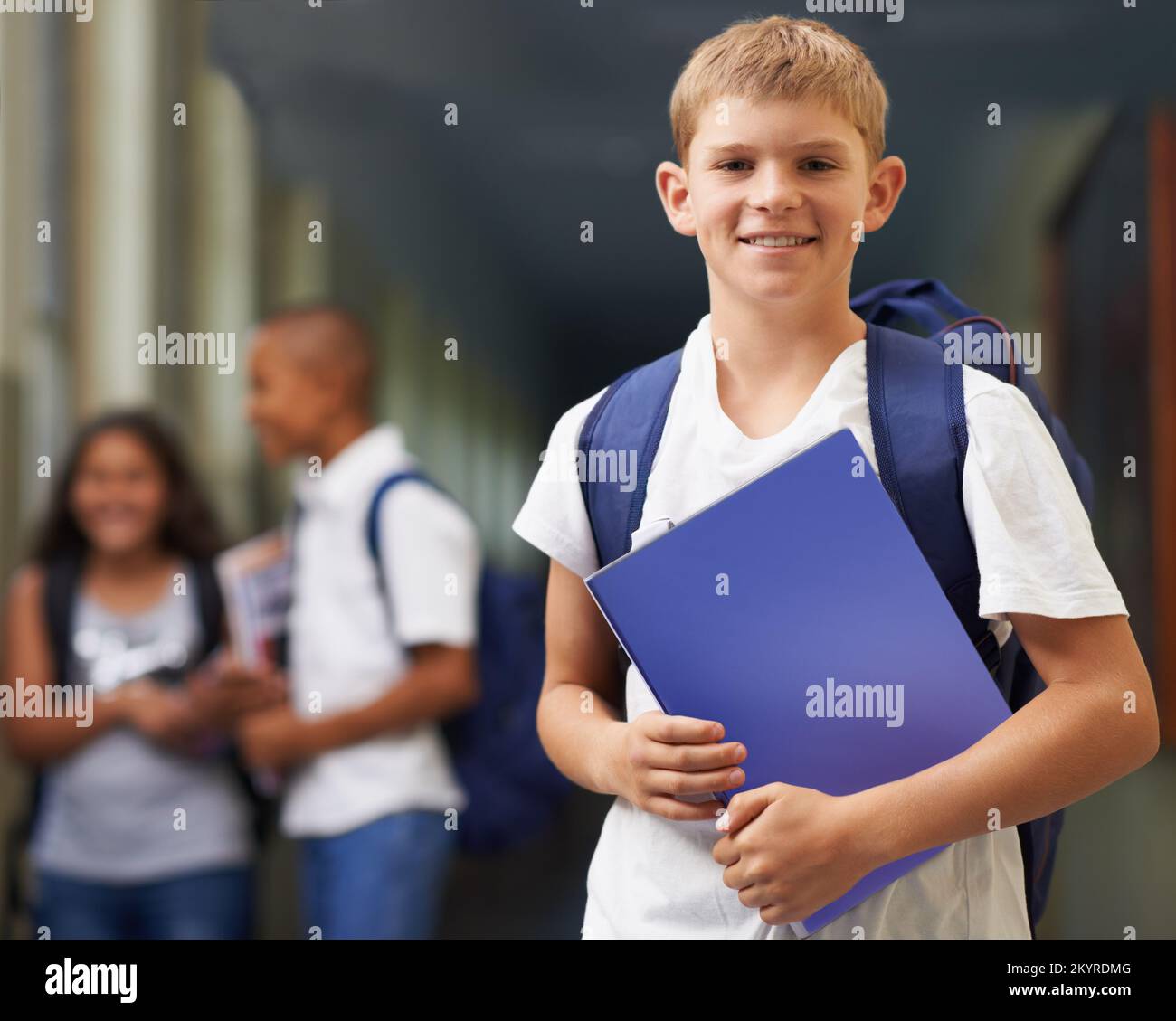 Hes a diligent student. Portrait of a happy school boy standing in the ...