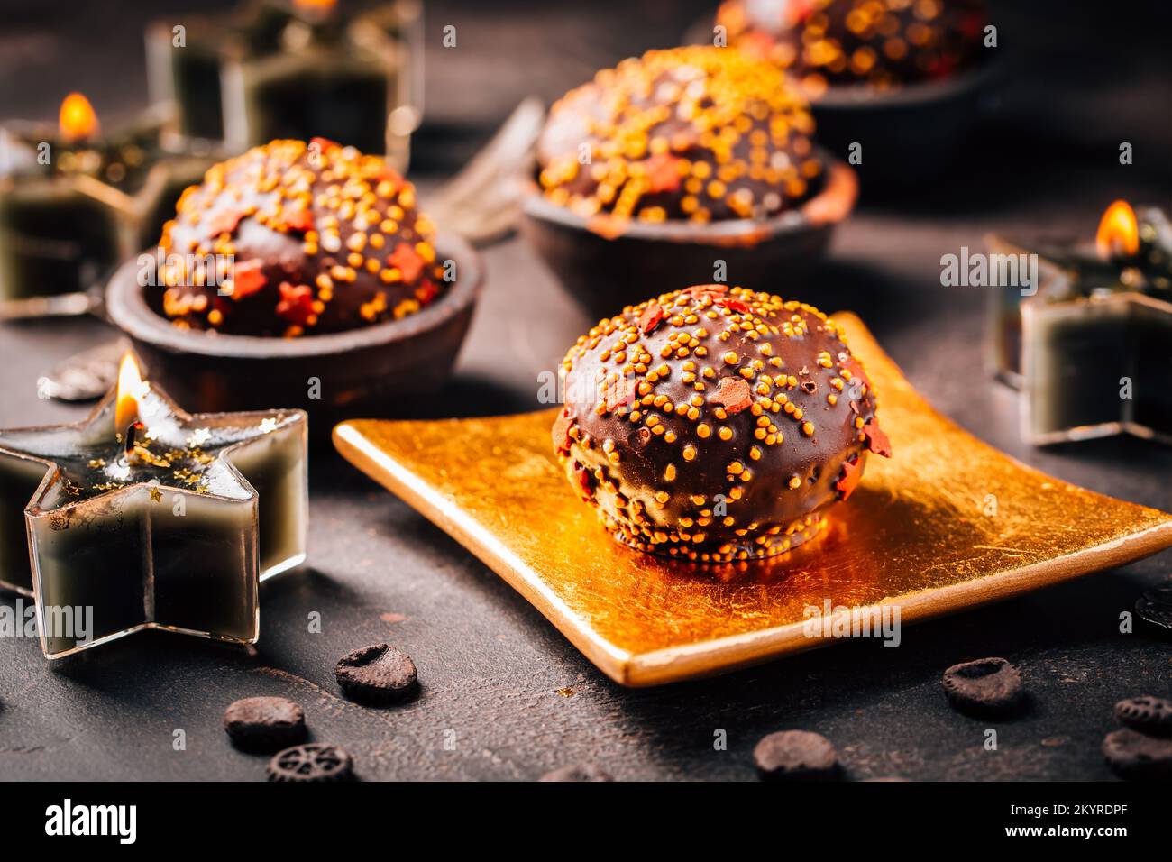 Small chocolate pastry cakes for Christmas with candles and ornaments ...