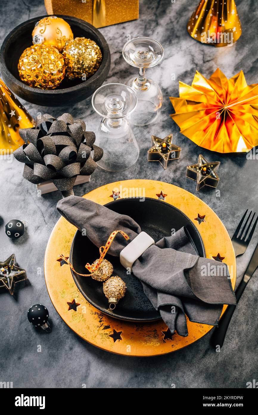 Glamorous black and gold place setting with modern plates for New Years ...