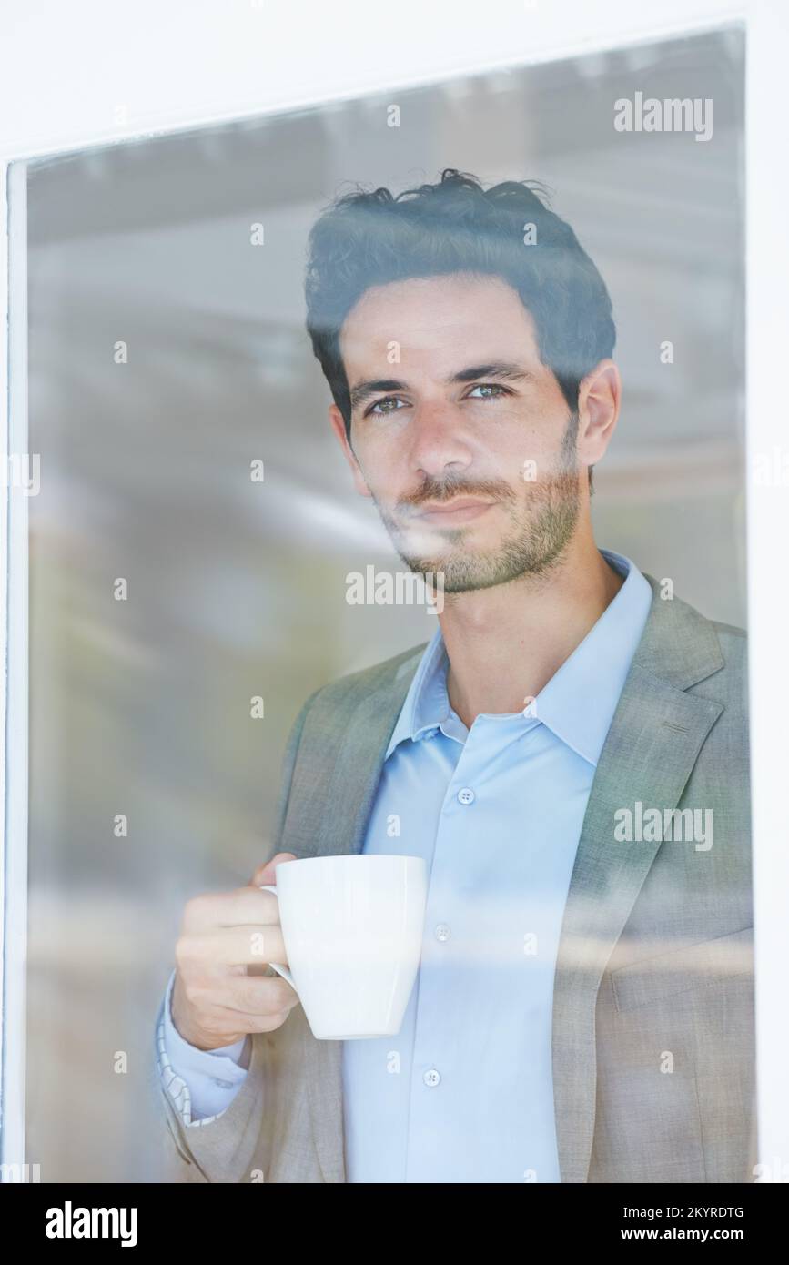 Taking time to enjoy his morning. Portrait of a handsome young man ...