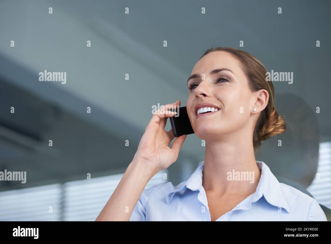 Calling a client. An attractive young businesswoman using her cellphone ...