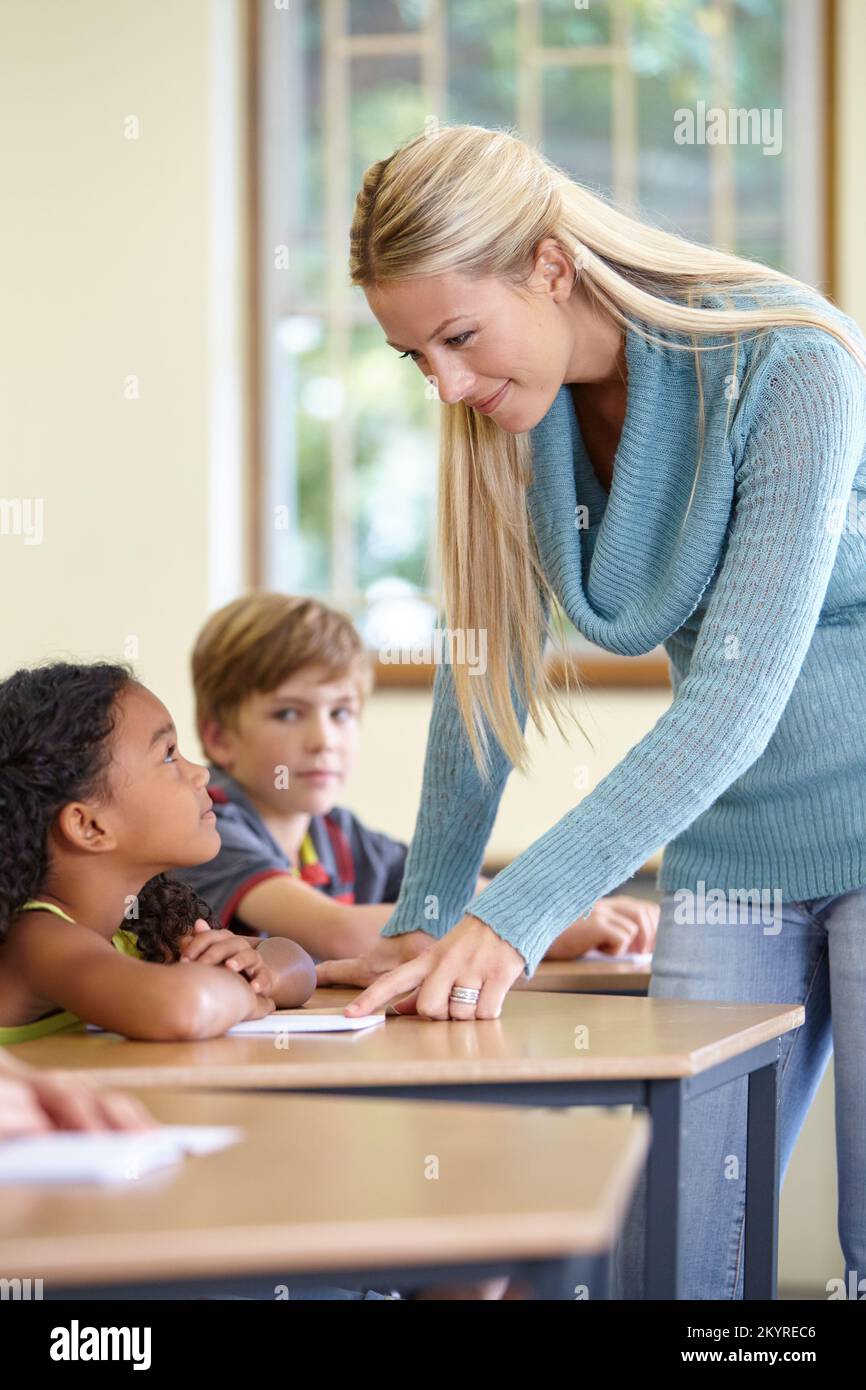 Teaching is the most important of professions. A young teacher helping ...