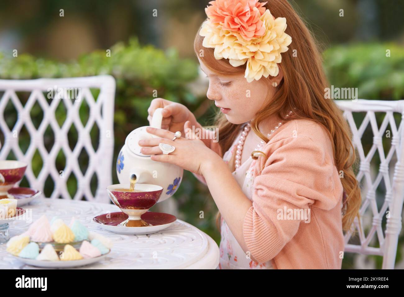Hosting a tea party. A cute little girl having a tea party outside ...