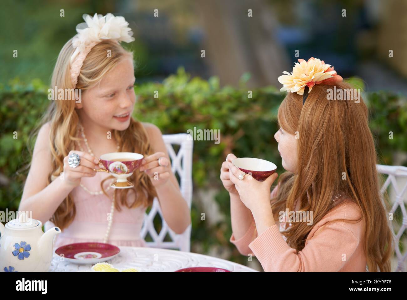 Having a make-believe tea party. Two young girls having a tea party in ...