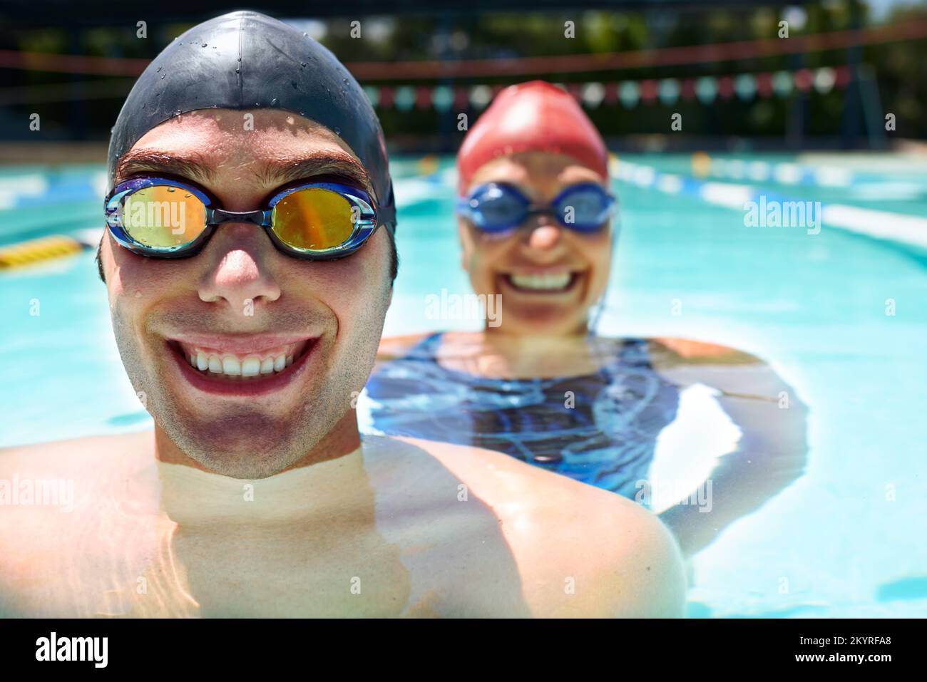 Ready For A Swim A Man And Woman Standing In A Pool Wearing Goggles