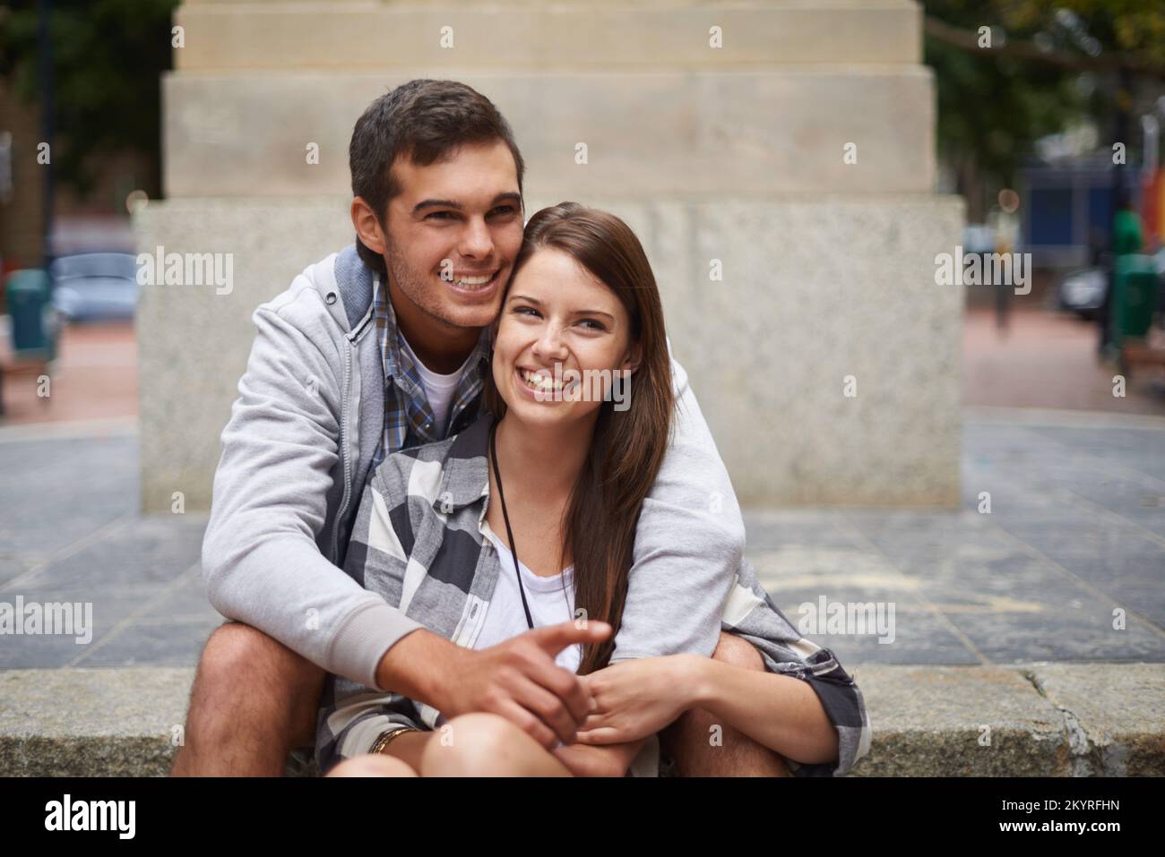 Sharing an intimate moment. A happy young couple sitting outside having ...