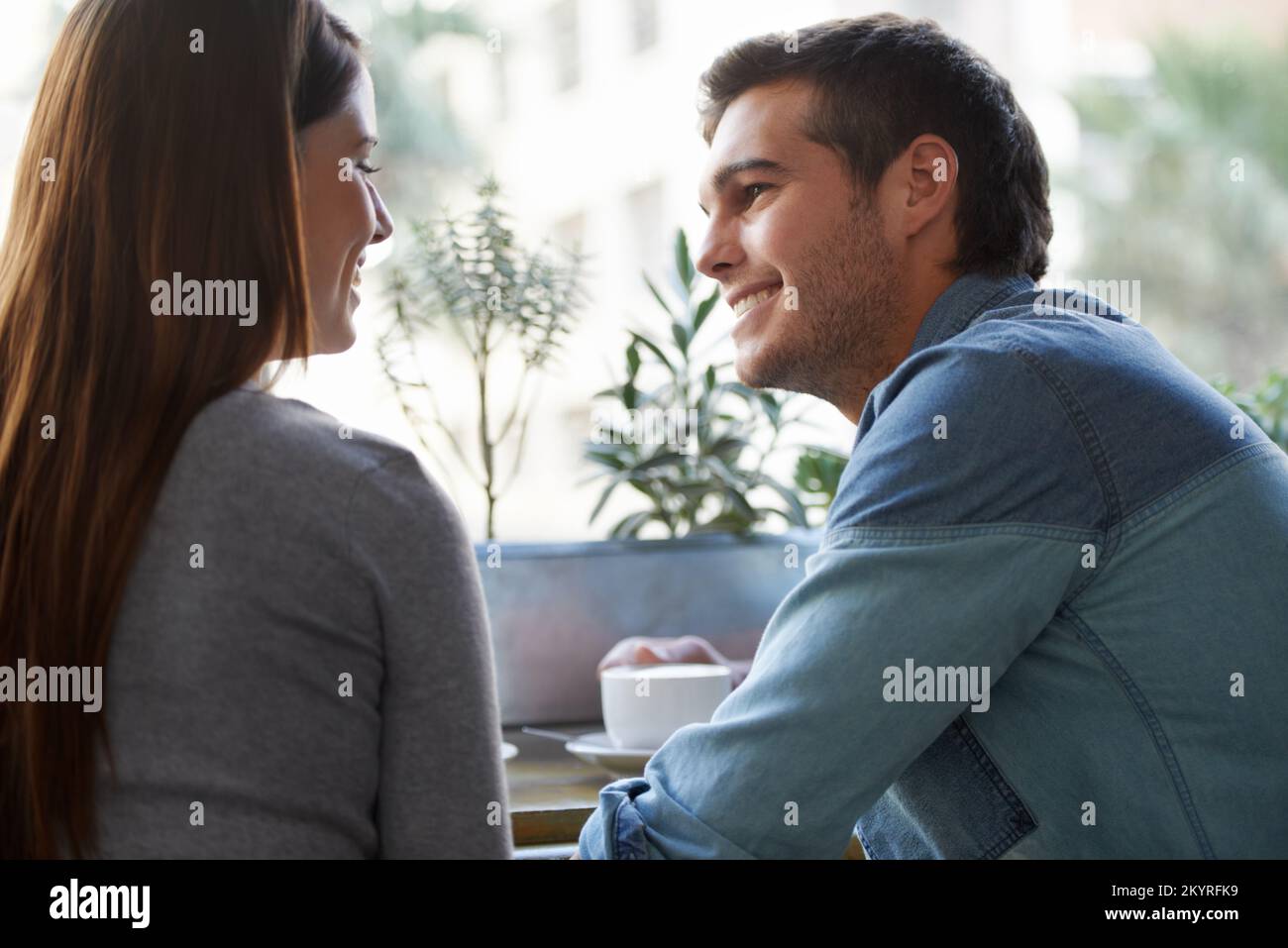Staring into her eyes...a young couple talking together in a cafe Stock ...