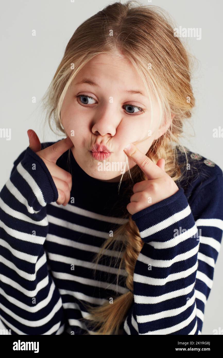 Feeling quirky. A cute girl pressing her cheeks with her fingers Stock ...
