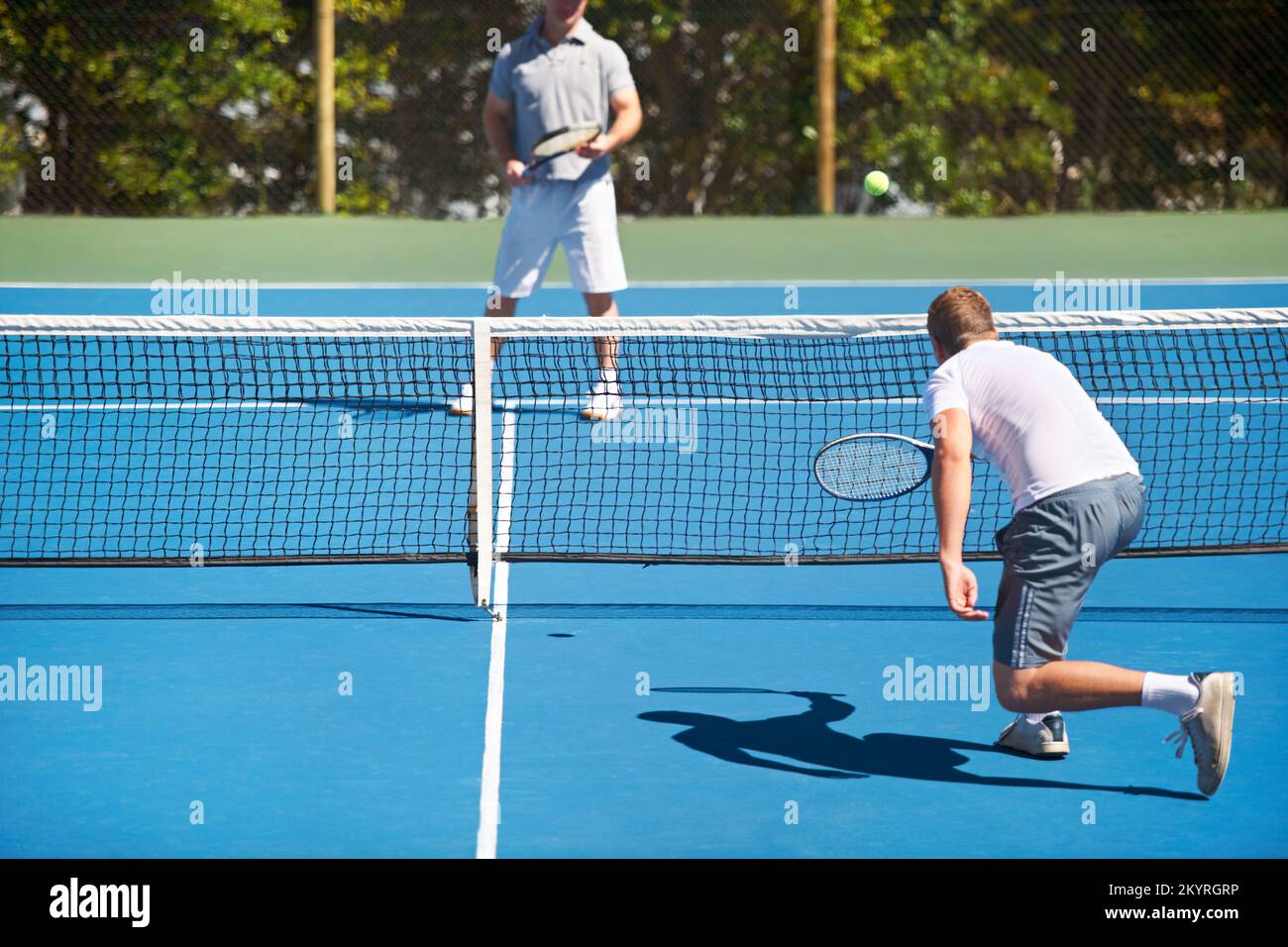Showing up to every tennis practice. two people playing tennis outside ...