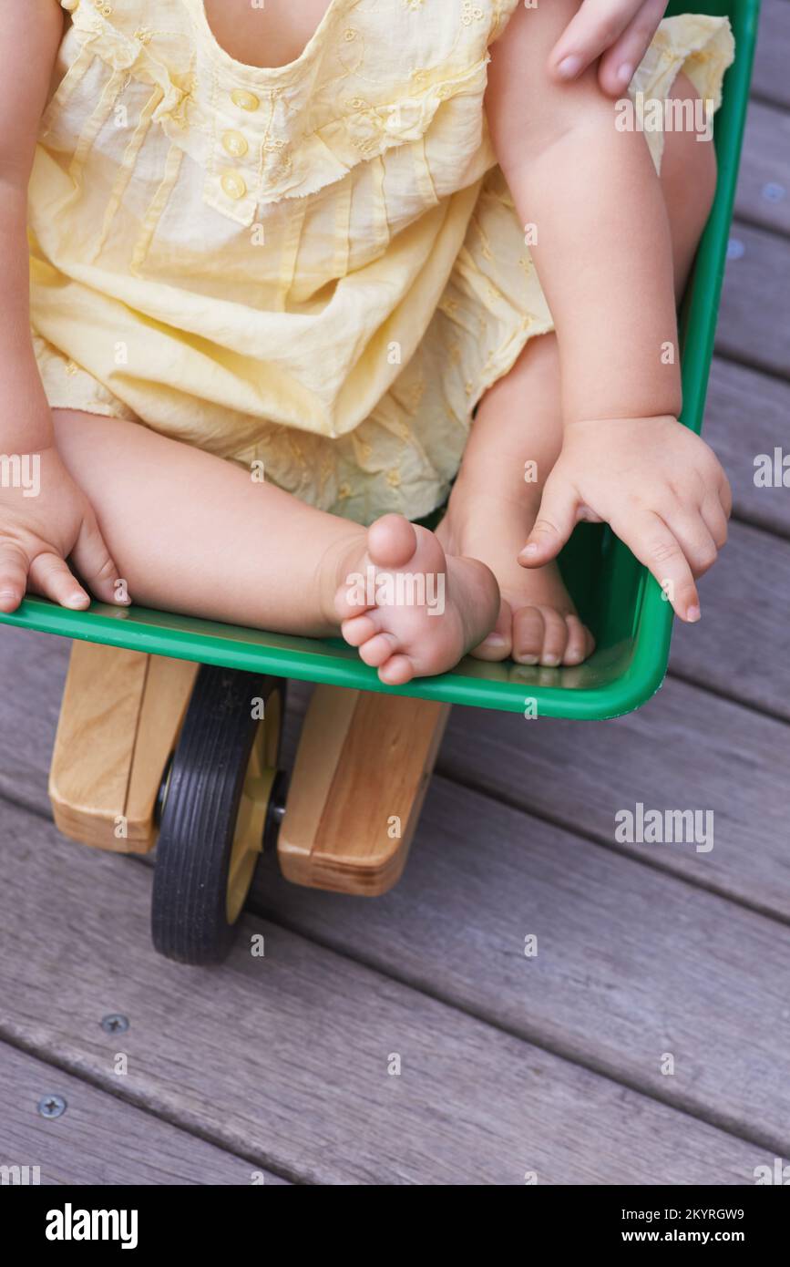 Push me faster, Mom. Cropped image of a baby girl being pushed in a toy ...