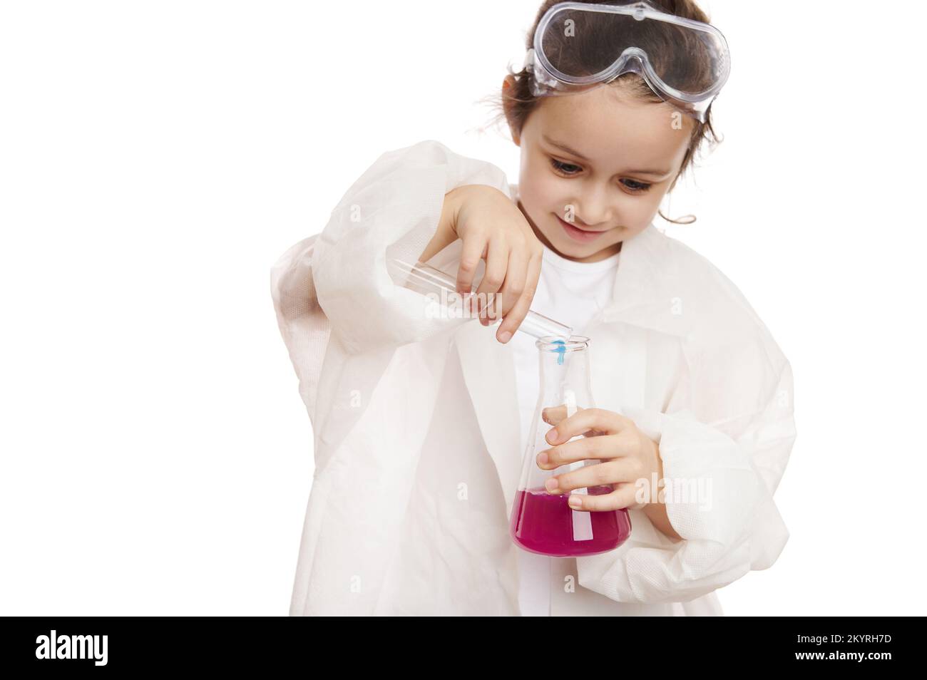Little girl pours reagent from test tube into flask with liquid ...