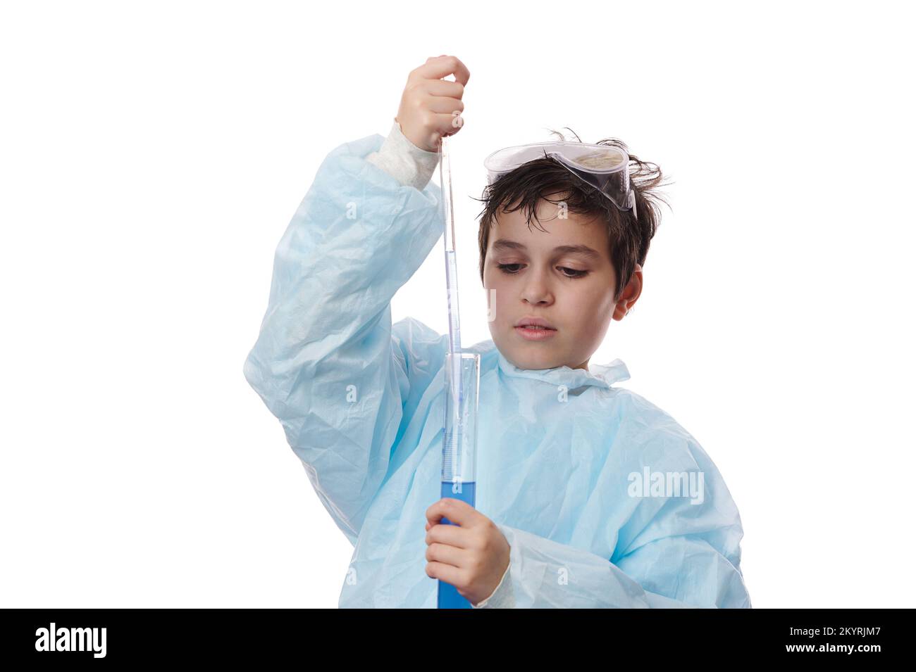 Smart teenage schoolboy fills graduated pipette with blue substance ...