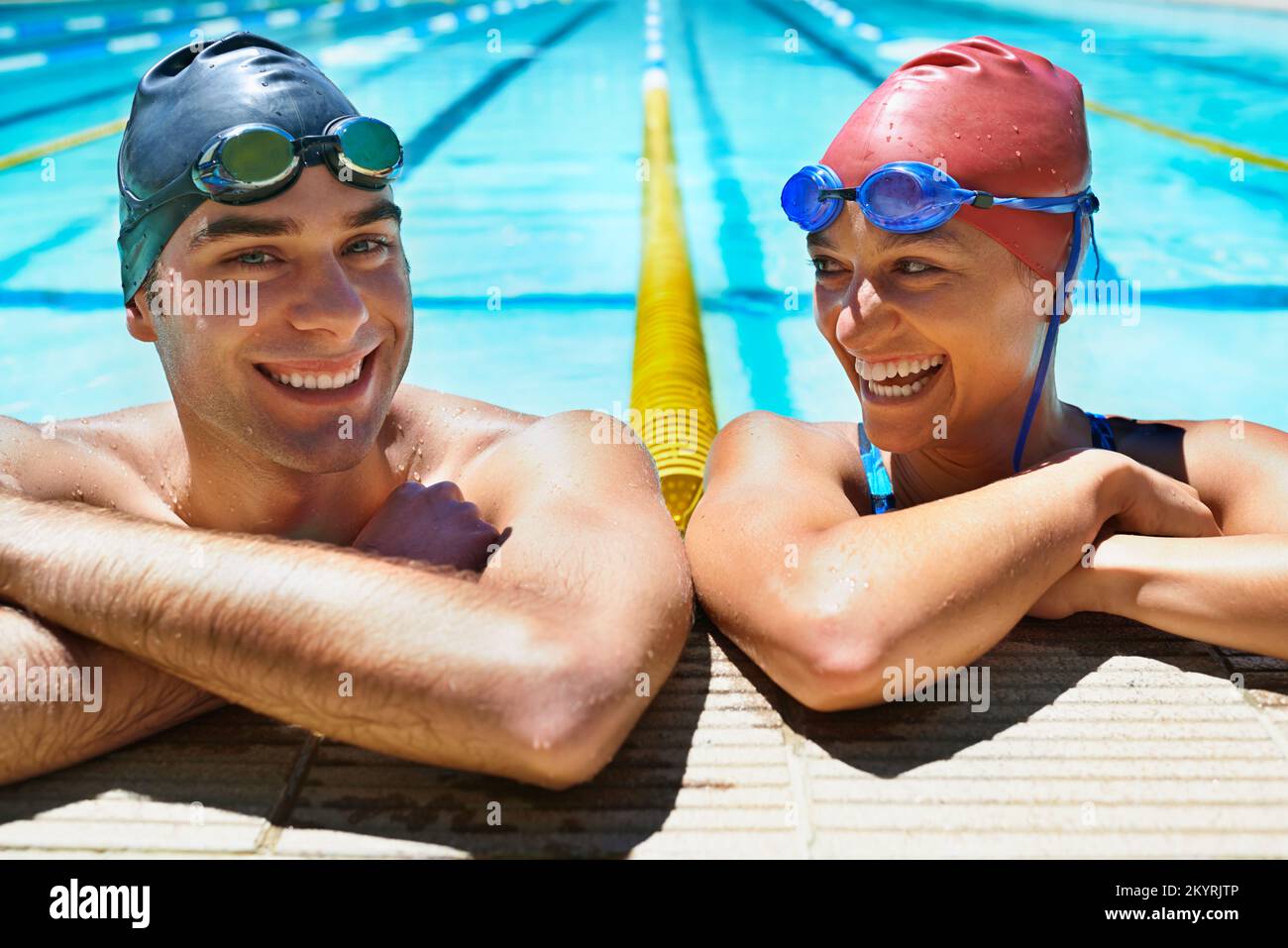 Ready for another lap. Two happy young swimmers standing in the pool ...