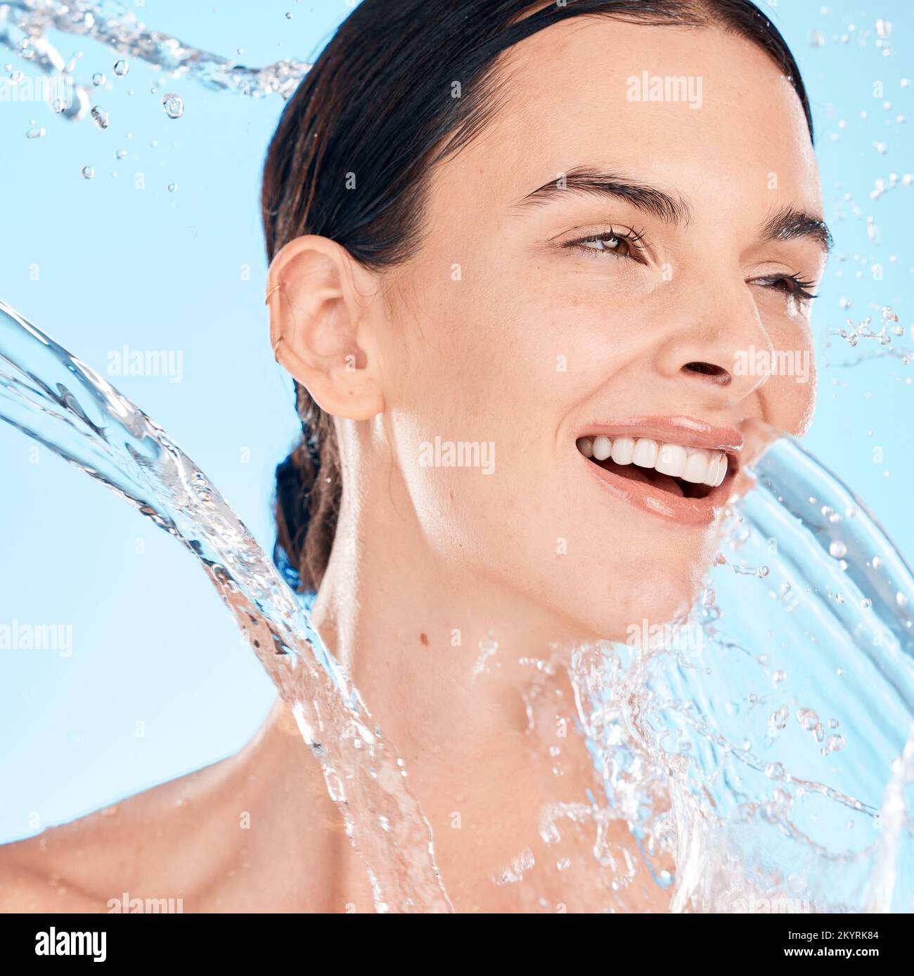 Woman, face and water splash for skincare cosmetics or beauty wellness for happiness in studio ...