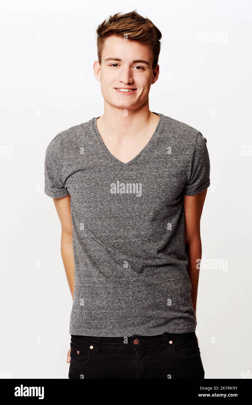 Smiling bashfully. Studio shot of young man smiling while standing with ...