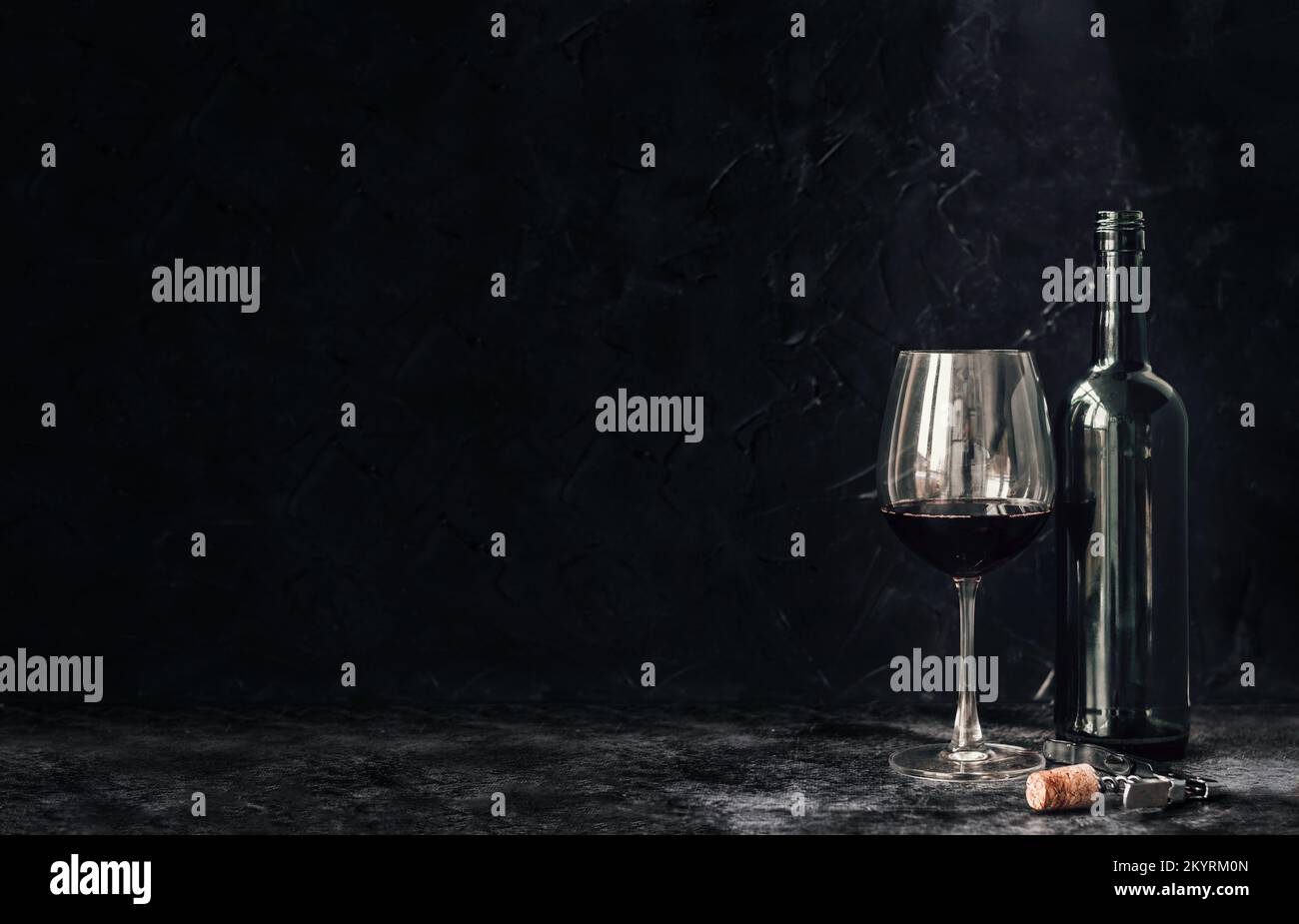 bottle red of wine with a glass on a black background Stock Photo - Alamy