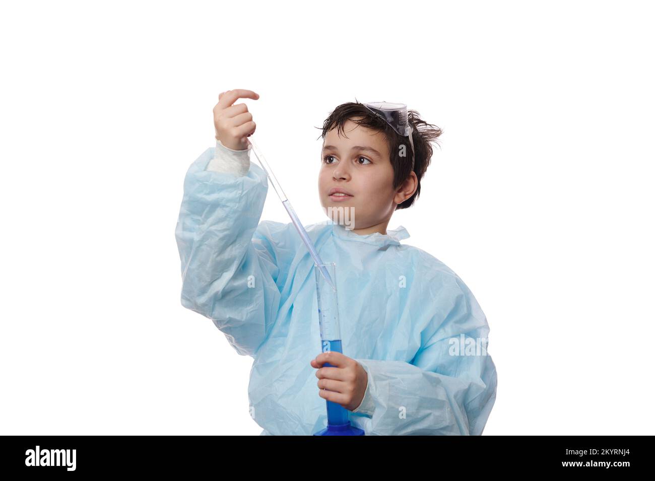 Schoolboy using graduated pipette, dripping few reagents in measuring ...