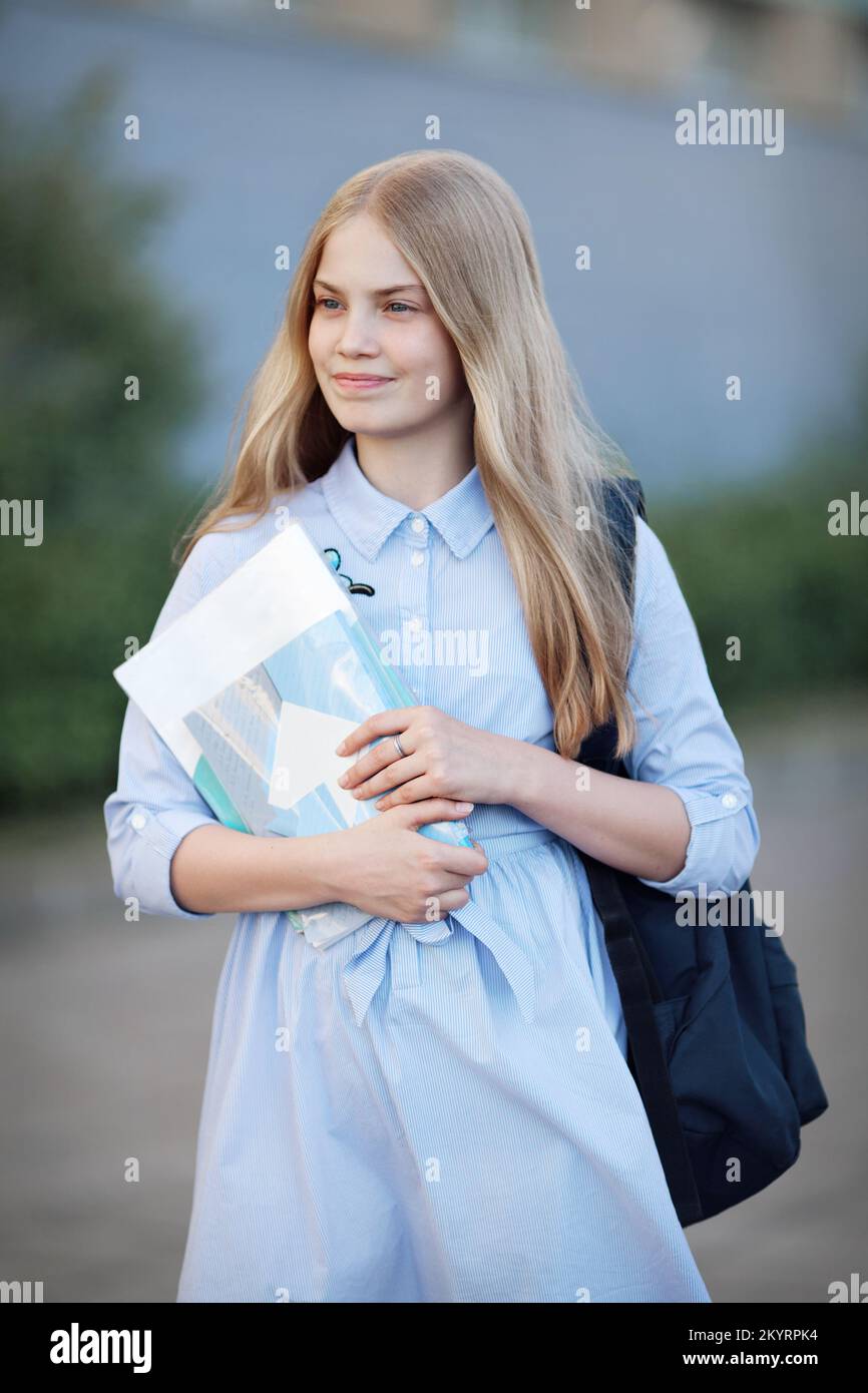 Portrait of beautiful teen girl student with long blonde hair. First ...