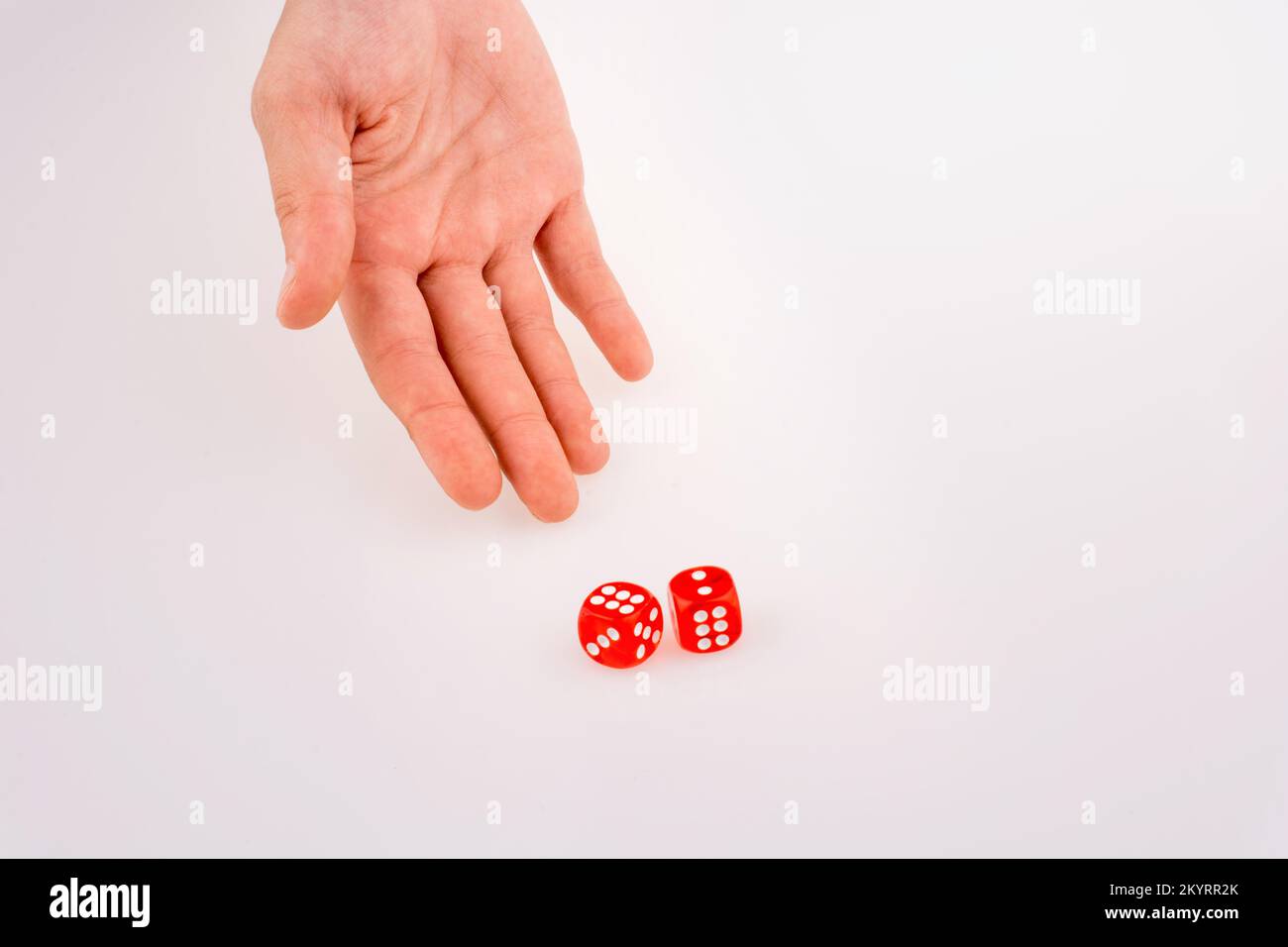 Hand holding red dice on a white background Stock Photo - Alamy