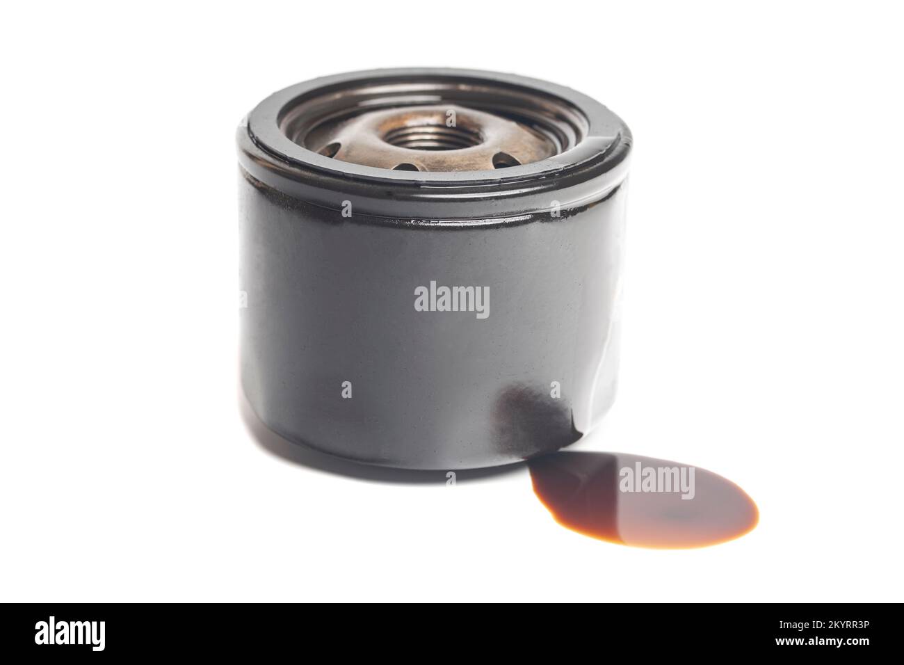 Car oil filter with a puddle of engine oil isolated on white background ...
