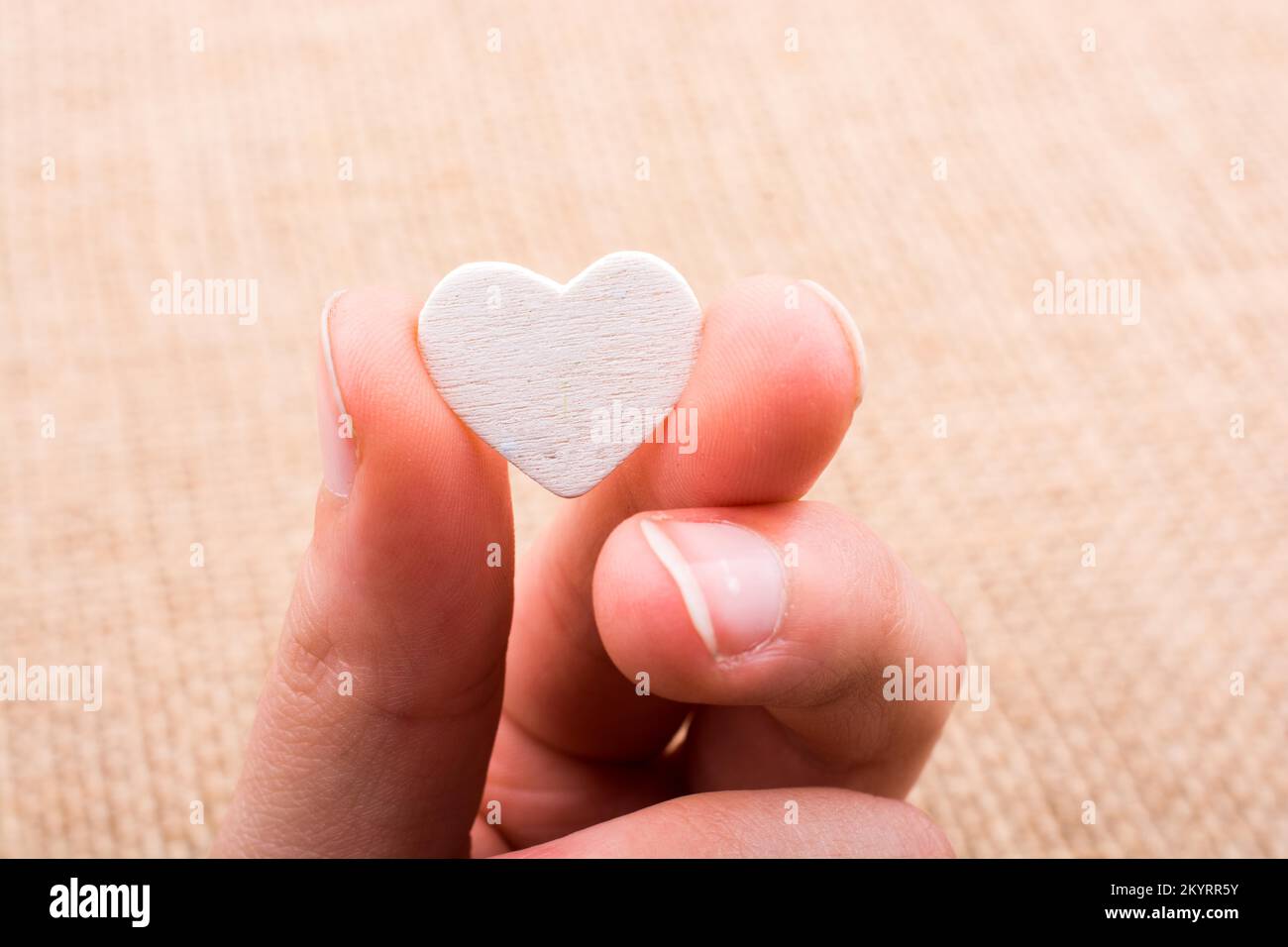Heart shaped object in hand on canvas Stock Photo - Alamy