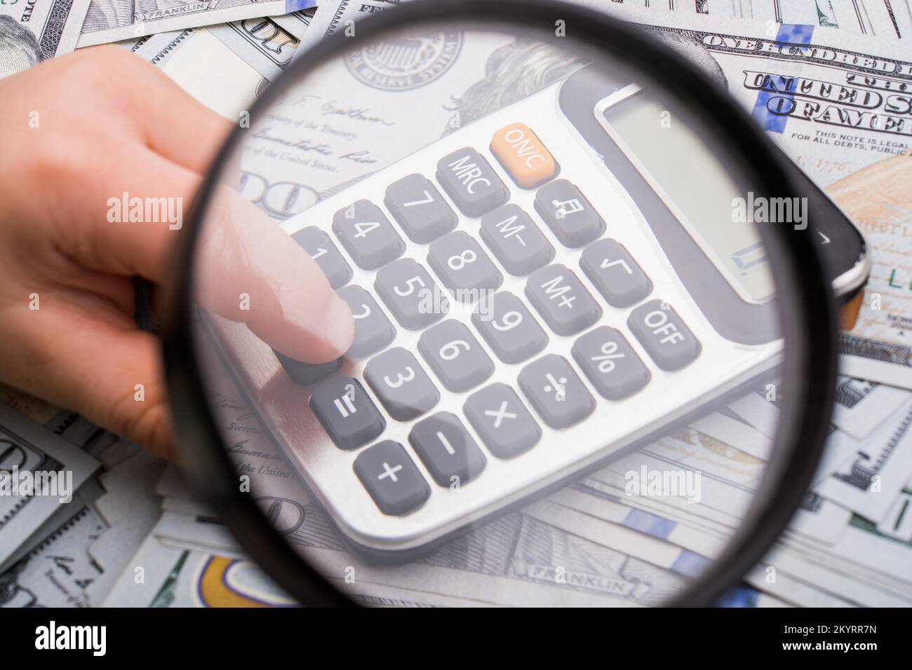 Magnifying glass is held over the banknote bundle of US dollar Stock ...