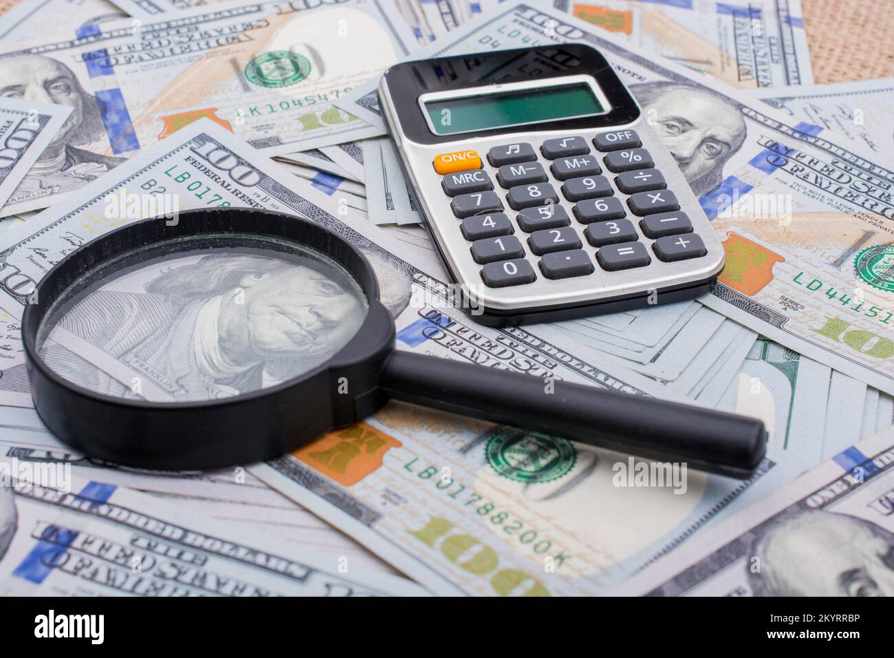 Magnifying glass is held over the banknote bundle of US dollar Stock ...