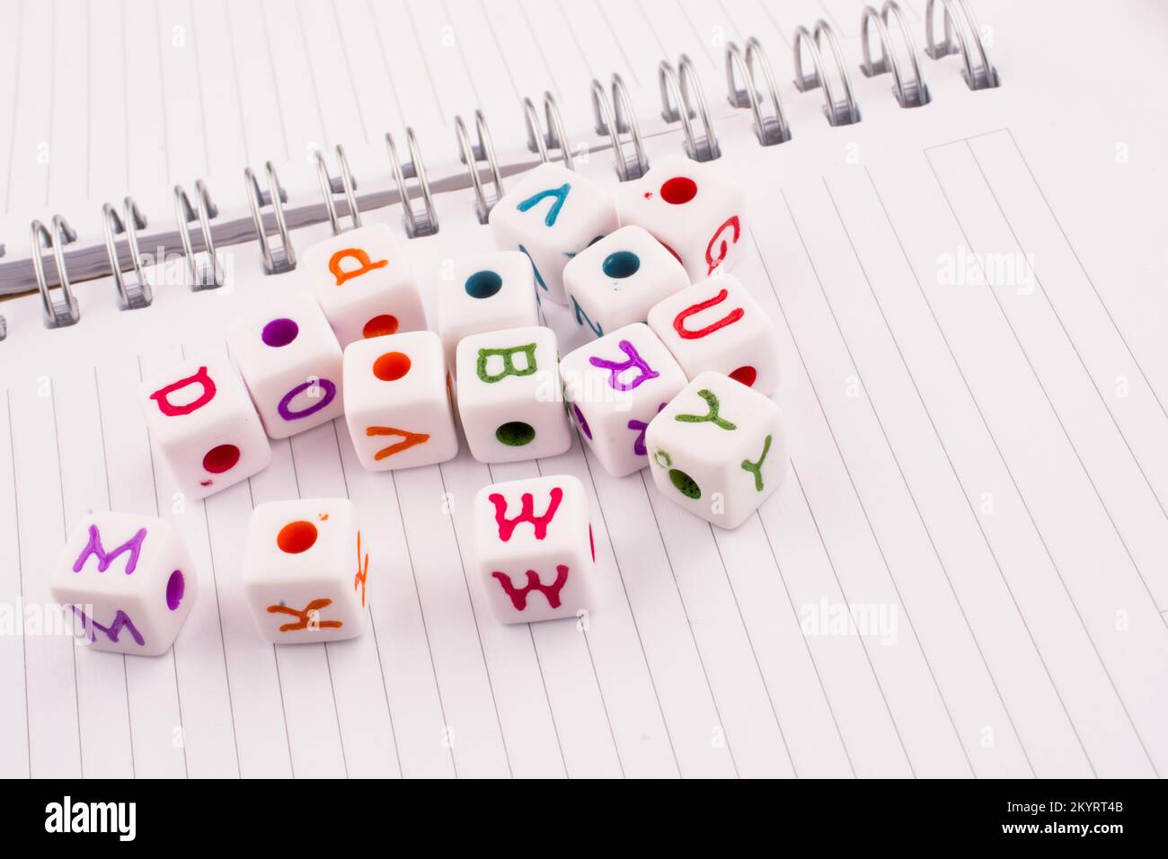 Letter cubes of alphabet of various color on a spiral notebook Stock ...