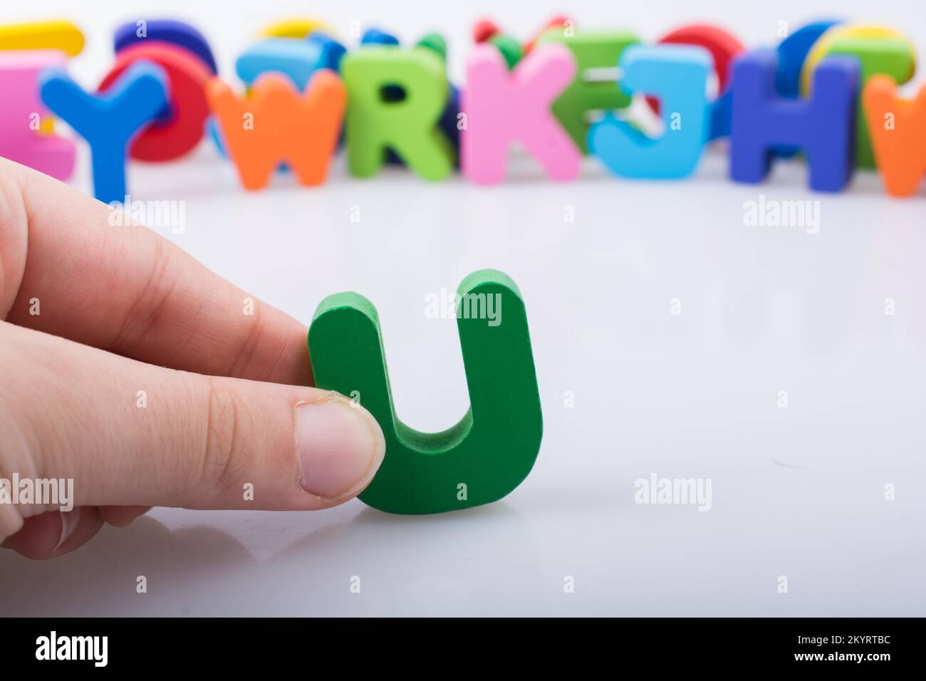 Hand holding letter cube U of made of wood Stock Photo - Alamy