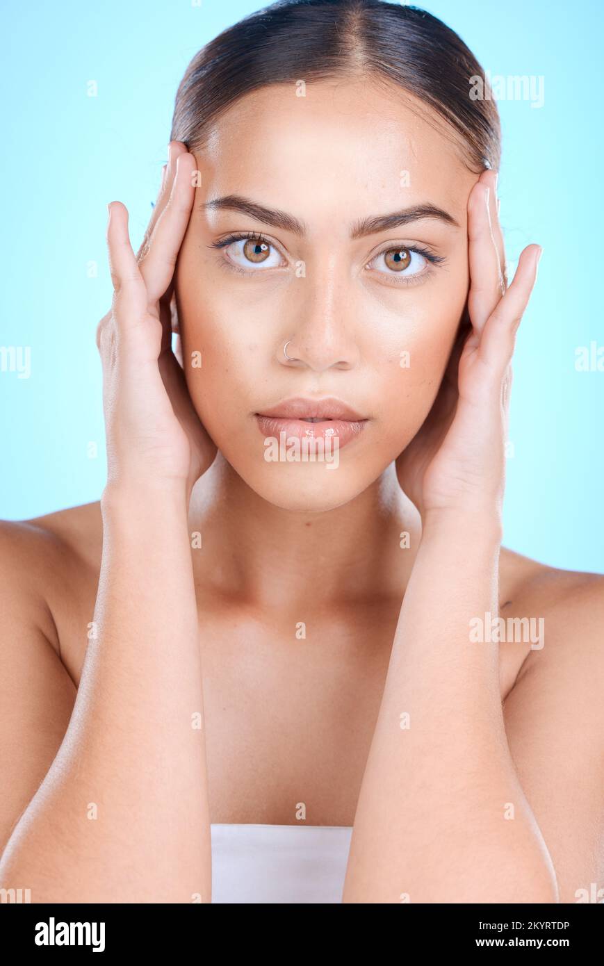 Woman, skincare or touching face with hands on blue background in ...
